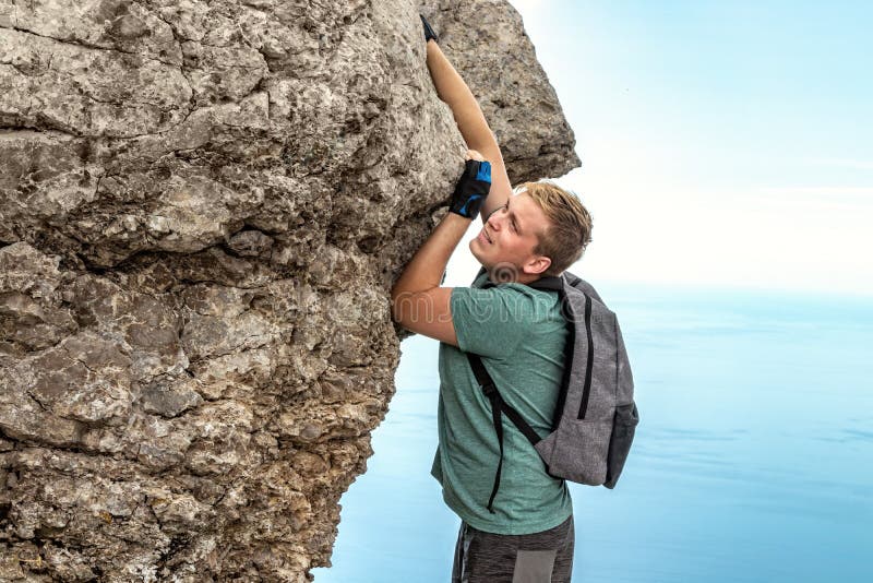 Young Man Hanging on Edge, Climbs Up the Rock Stock Image - Image of ...