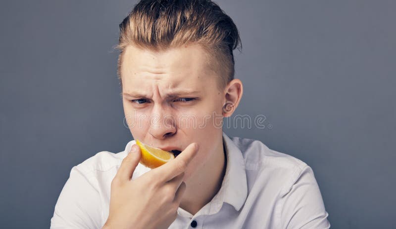 Young man tasting lemon. stock photo. Image of adult - 115277368