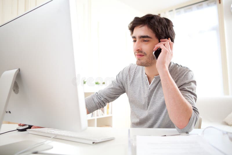 Young Man Having a Call in Front of Computer Stock Image - Image of ...