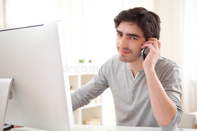 Young Man Having a Call in Front of Computer Stock Image - Image of ...