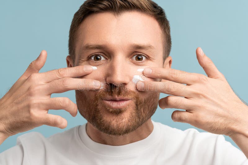 Young Man Having Fun Applying Face Cream on Cheeks Two Hands Looking at ...