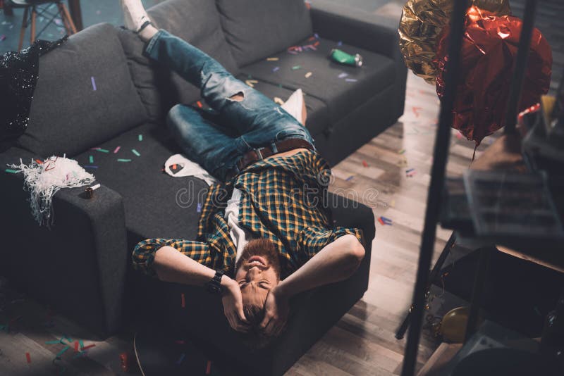 Young Man with Headache and Hangover Lying on Sofa after Party Stock ...