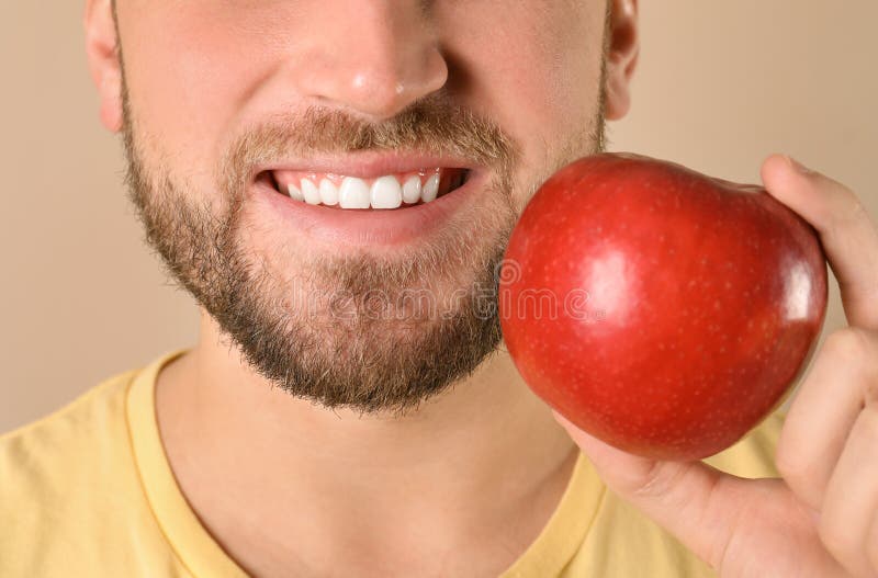 Young Man with Healthy Teeth and Apple on Color Background Stock Photo ...
