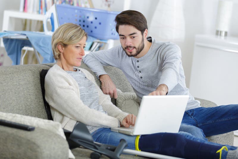 Young Man Helping Injured Woman on Computer Stock Image - Image of ...