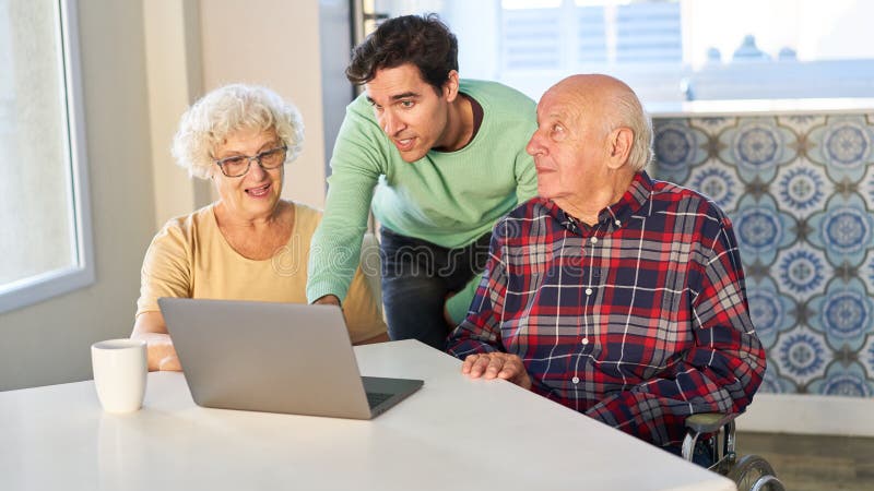 Young Man Helping Senior Couple on Laptop Computer Stock Photo - Image ...