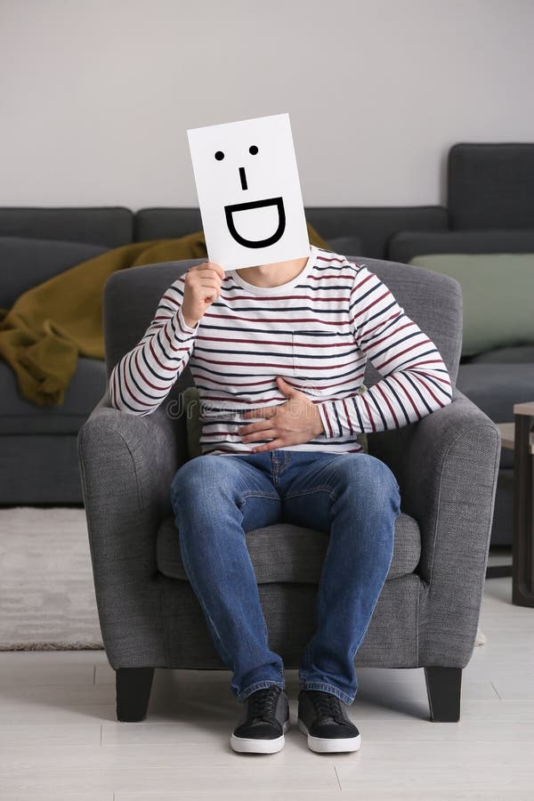 Young Man Hiding Face Behind Sheet of Paper with Drawn Emoticon while ... Young Man Hiding Face Behind Sheet of Paper with Drawn Emoticon while ...