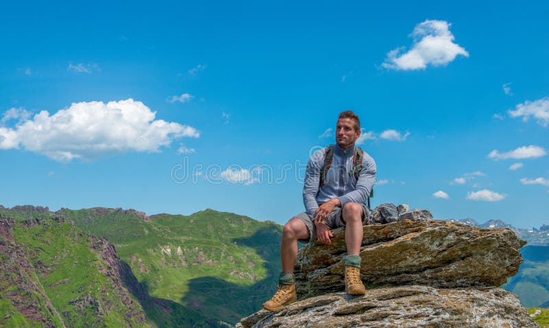 Young Man Hiker Sitting on a Rock in Mountain Stock Photo - Image of ...