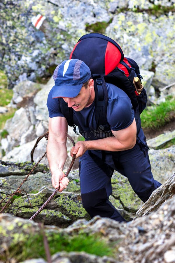 Young Man Hiking on Difficult Mountain Trail with Hanging Cable Stock ...