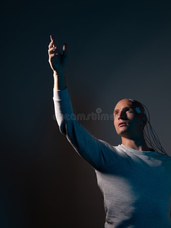 A Young Man with His Head Entangled with Wires, Pulls His Hands Up ...