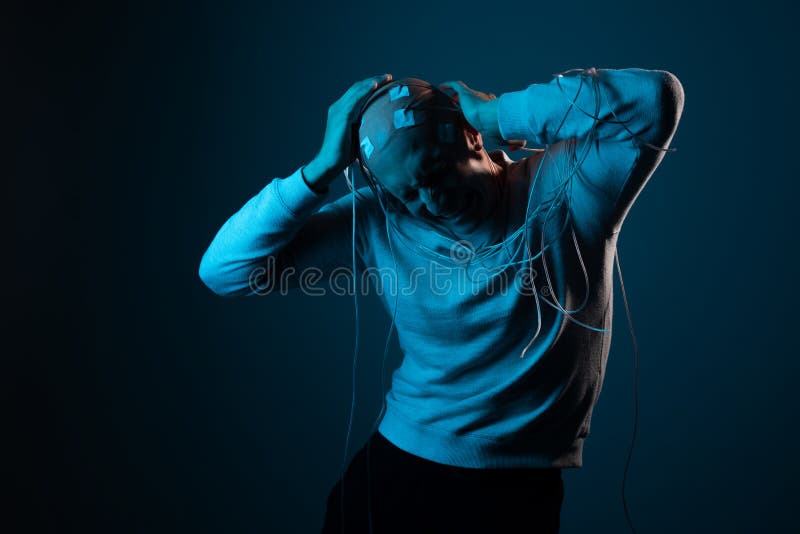 Young Man with a Head Entangled with Wires and with a Robotic Arm ...