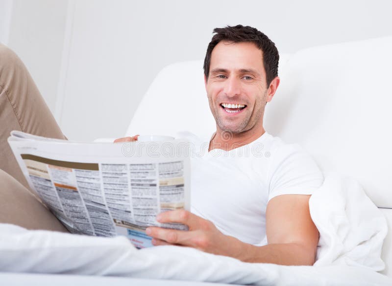 Young Man Holding Cup in Hand Reading Newspaper Stock Photo - Image of ...