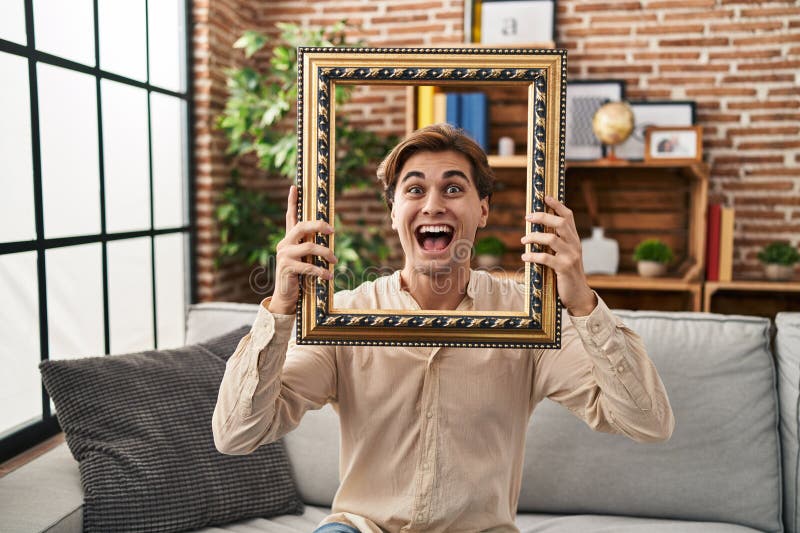 Young Man Holding Empty Frame Celebrating Crazy and Amazed for Success ...