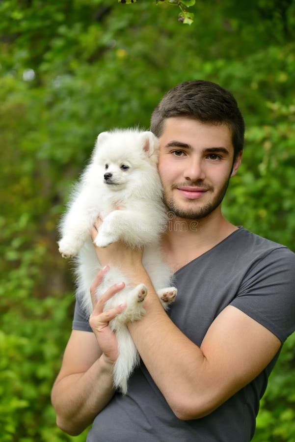 Young Man Holding German Spitz Puppy Stock Photo - Image of canine ...