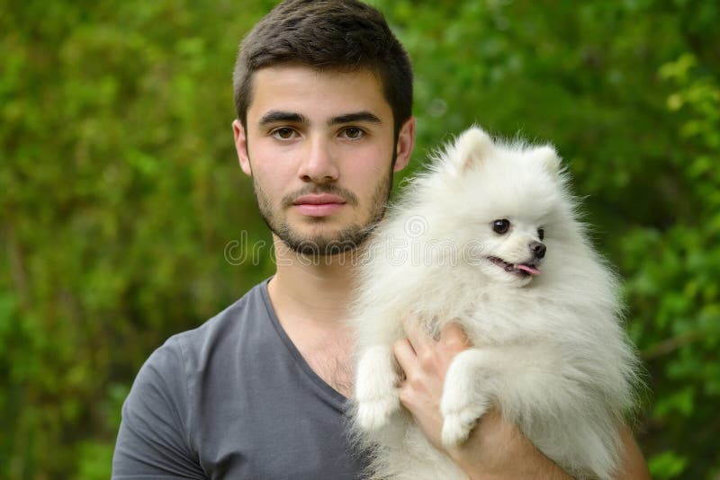 Young Man Holding German Spitz Puppy Stock Image - Image of friends ...