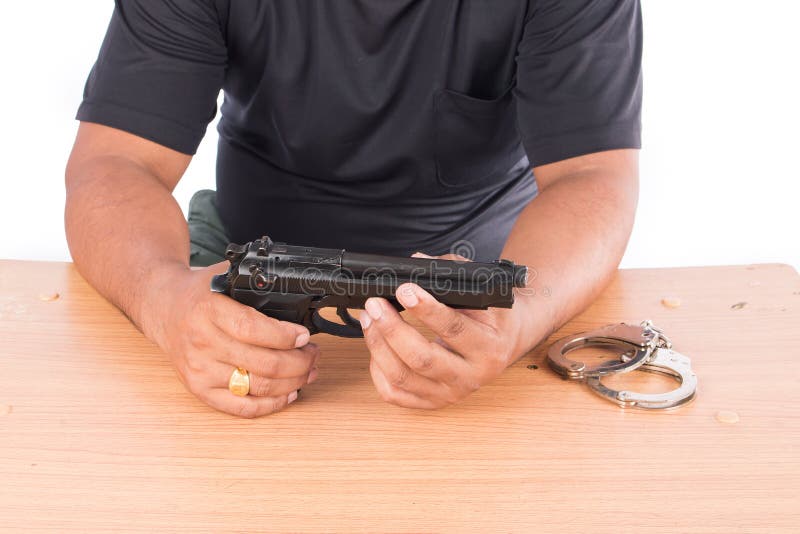 Young Man Holding Gun On Table Stock Image - Image of hole, chair: 73899651