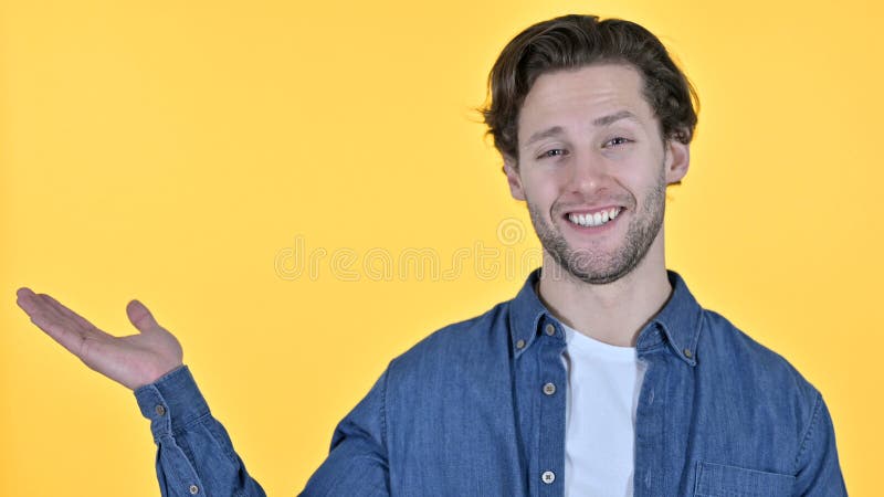 Young Man Holding Hand Out, Product Placement on Yellow Background ...