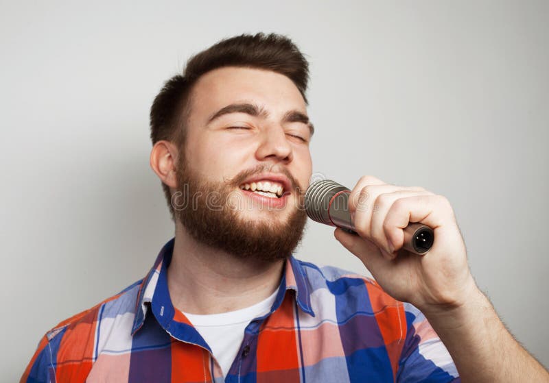 Young Man Holding a Microphone and Singing. Stock Photo - Image of ...