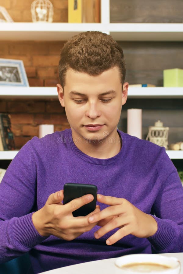 Young Man Holding a Mobile Phone and Smiling Stock Photo - Image of ...