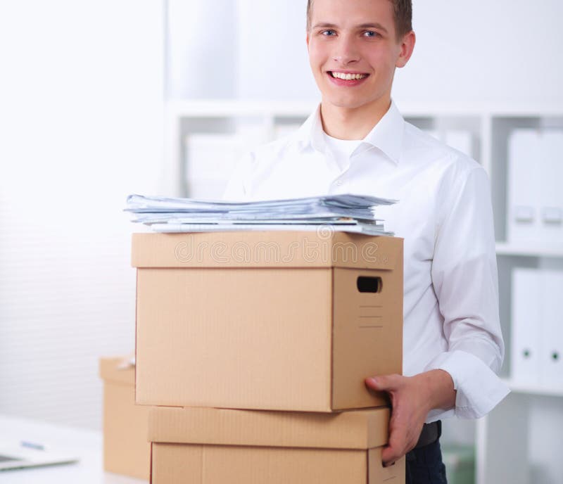 Young Man Holding a Stack of Cardboard Boxes Standing in Office Stock ...