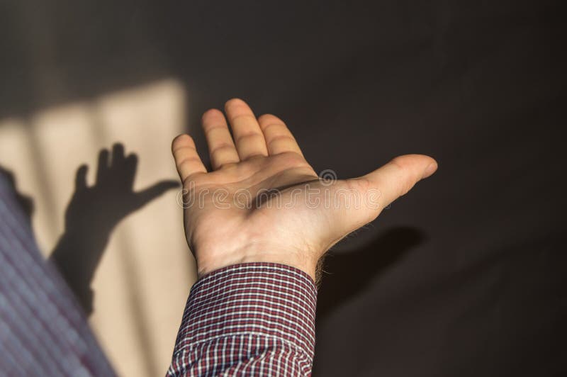 The Young Man Holds an Empty Hand with His Palm Up, a Shadow on the ...