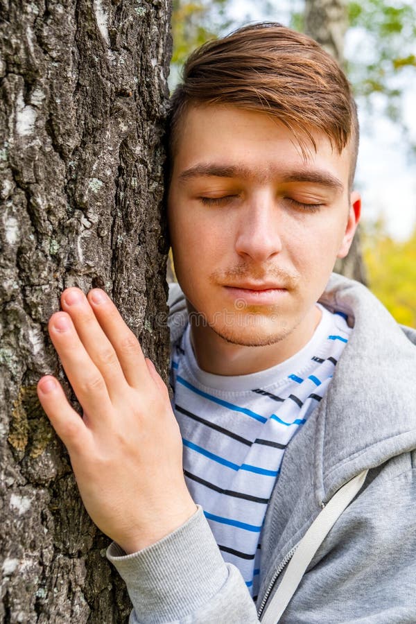 Young Man with a Tree stock image. Image of lean, bark - 221420007