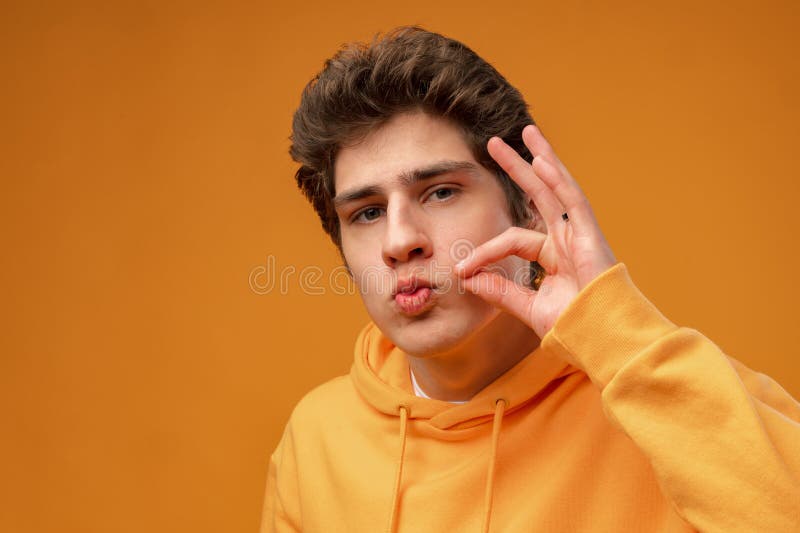 Young Man Hushing at Camera and Telling To Be Quiet on Yellow ...