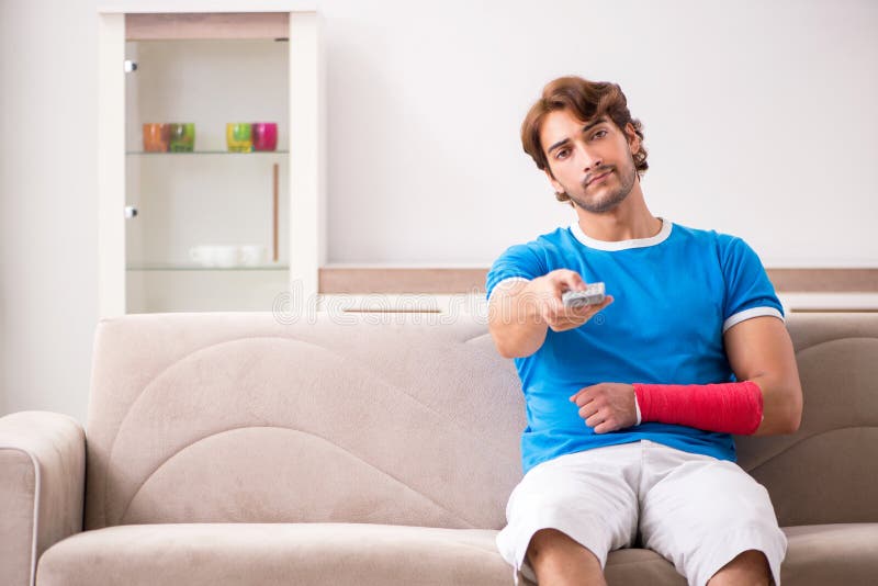 The Young Man with Injured Arm Sitting on the Sofa Stock Photo - Image ...
