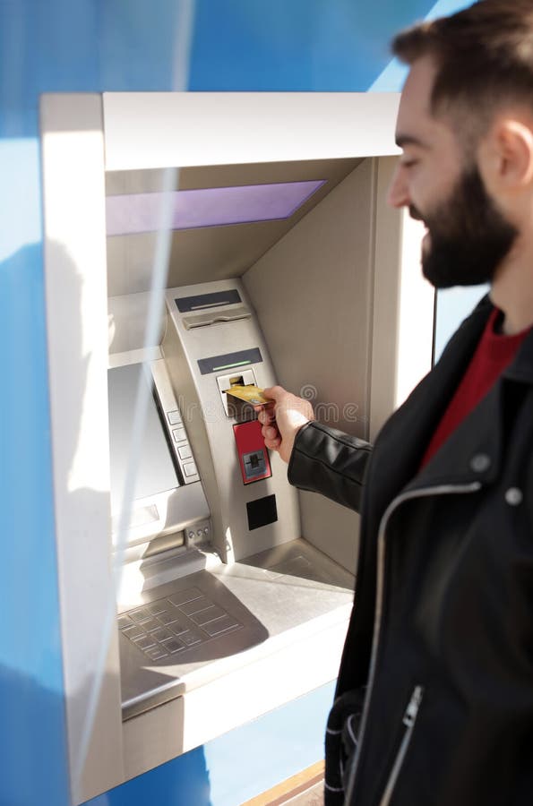 Young Man Inserting Credit Card into Cash Machine Stock Photo - Image ...