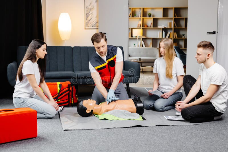 Young Man Instructor Helping To Make First Aid Heart Compressions with ...