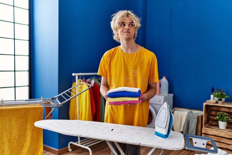 Young Man Ironing Clothes at Home Smiling Looking To the Side and ...
