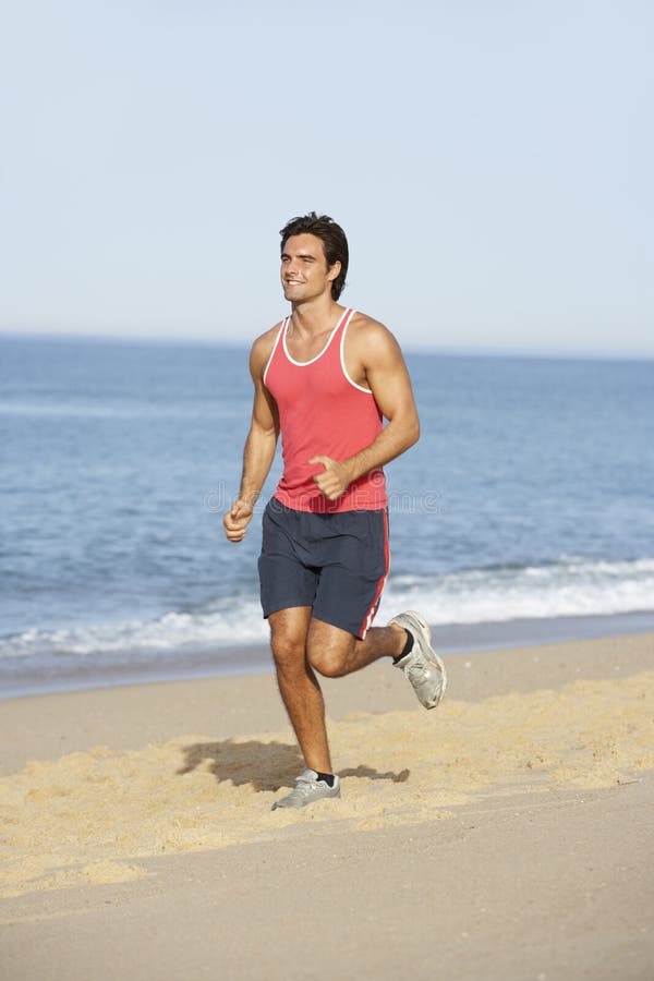 Young Man Jogging Along Beach Stock Image - Image of healthy, shore ...