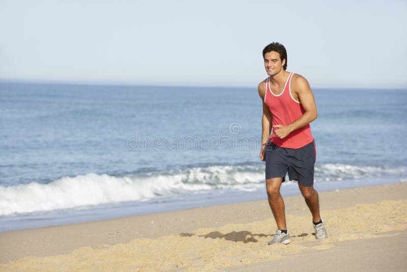 Young Man Jogging Along Beach Stock Photo - Image of running, jogging ...