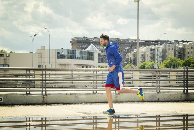Young man jogging outdoors stock image. Image of sport - 71712243