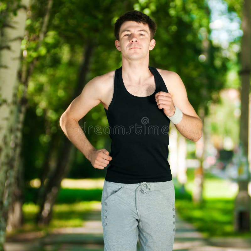 Young man jogging in park stock image. Image of cheerful - 23123167