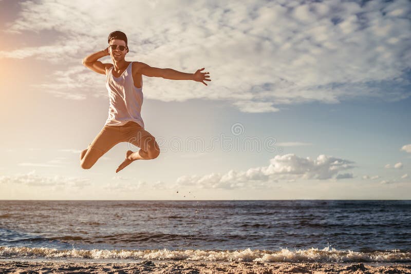 Young man jumping on beach stock image. Image of landscape - 97891559