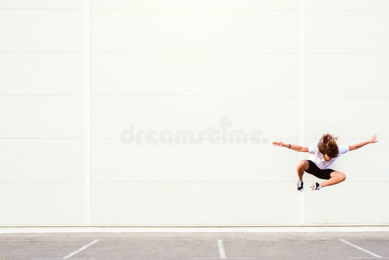 Young man jumping mid air stock photo. Image of fashionable - 186214690