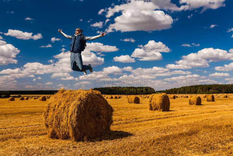 Young Man Jumping Over Haystack on the Summer Day. Stock Photo - Image ...