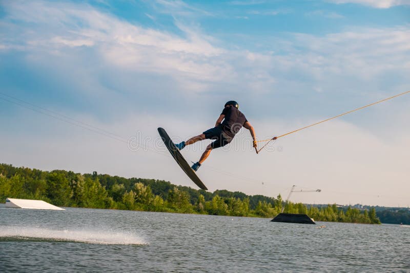 Young Man Jumping Over Water Surface of River on Wakeboard Stock Photo ...