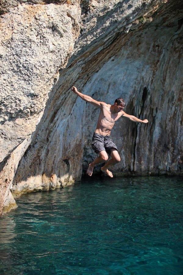 Young Man Jumping into Sea from Cliff Stock Image - Image of cliff ...