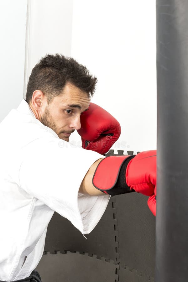Young Man in Kimono Throwing Punches at a Heavy Punching Stock Image ...