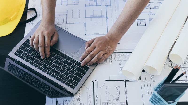 Young Man with a Laptop Plotting a System of Building Structures in ...