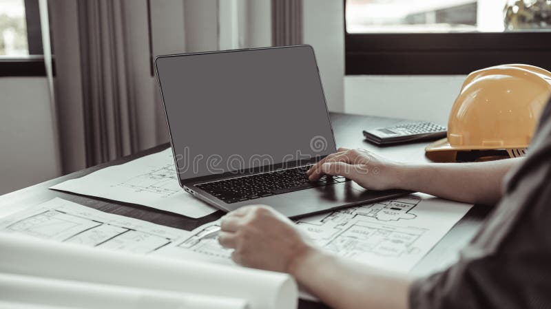 Young Man with a Laptop Plotting a System of Building Structures in ...