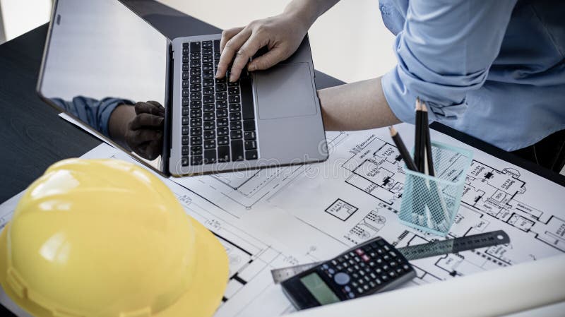 Young Man with a Laptop Plotting a System of Building Structures in ...