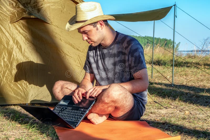 A Young Man with a Laptop Working and Resting in Nature. Freelance Work ...