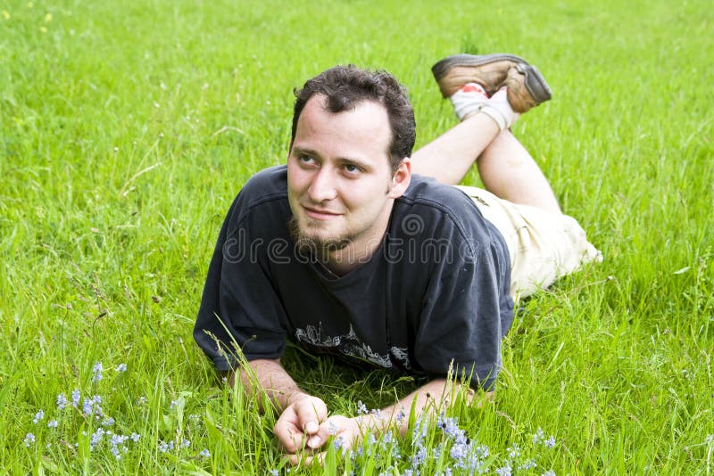 Young man laying in grass stock photo. Image of brunette - 5316466