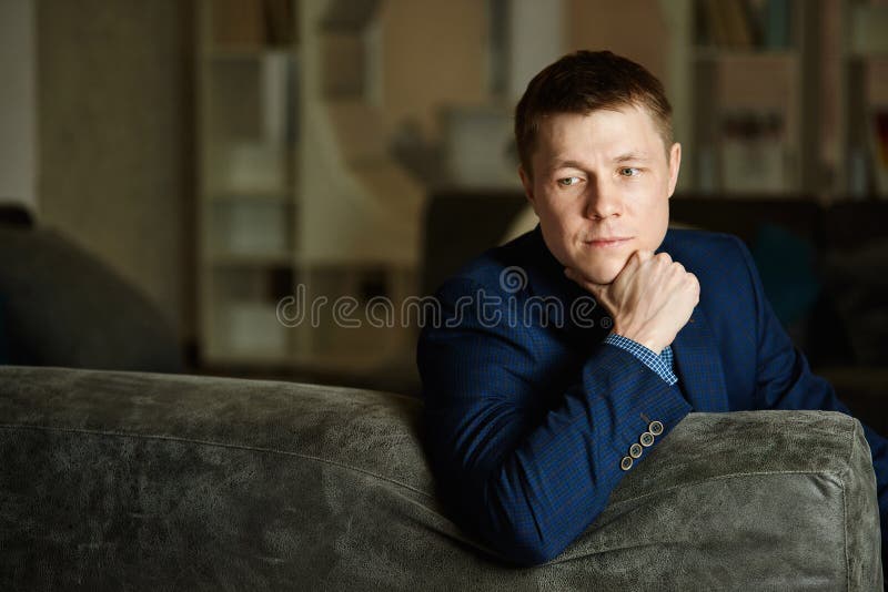 The Young Man Leaned Thoughtfully on the Back of the Sofa, Looking Down ...