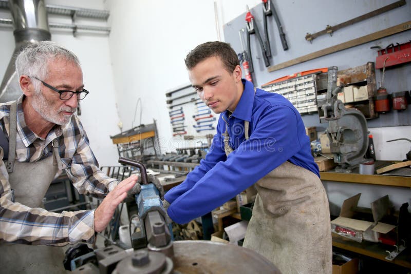 Young Man Learning Ironworks with Instructor Stock Image - Image of ...