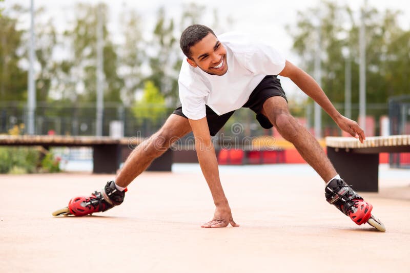 Young Man Learning Riding the Rollers and Laughing while Falling Down ...