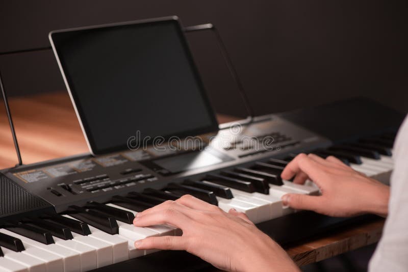 Young Man Learning To Play Piano, Using Keyboard and Tablet with Stock ...