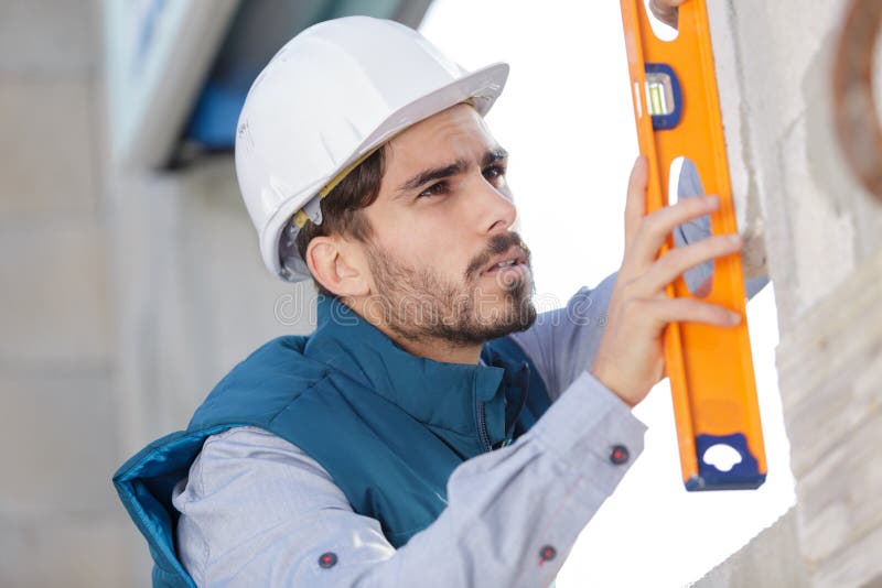 Young man levelling wall stock photo. Image of professional - 200446902